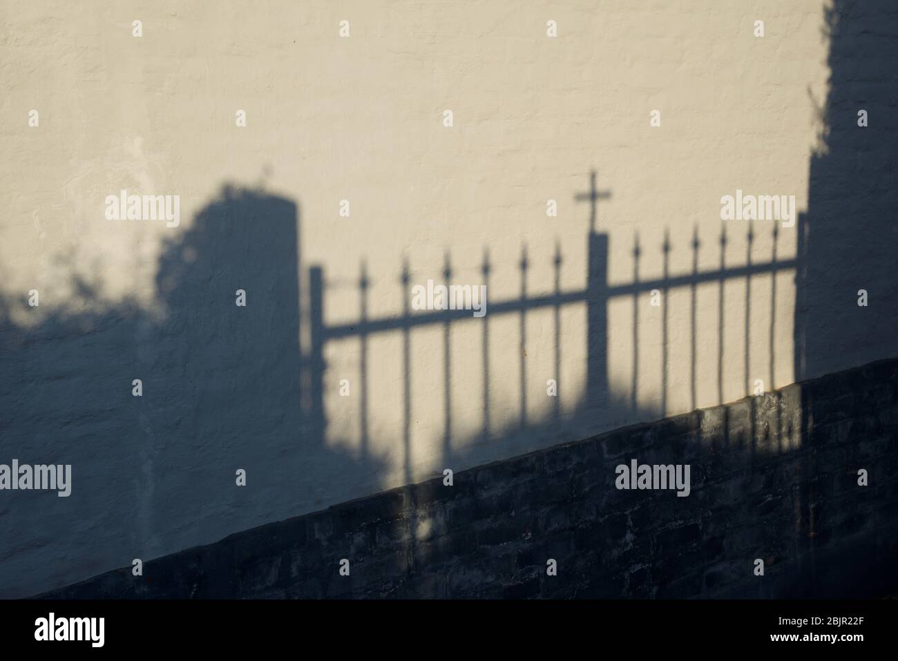 Cast shadow: the shadow of a closed entrance gate to a church is cast ...