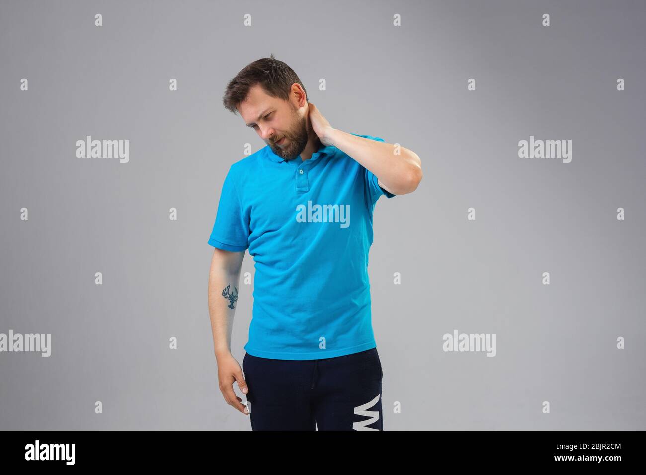 Young caucasian man suffers from neck pain, feels sick, ill and ...