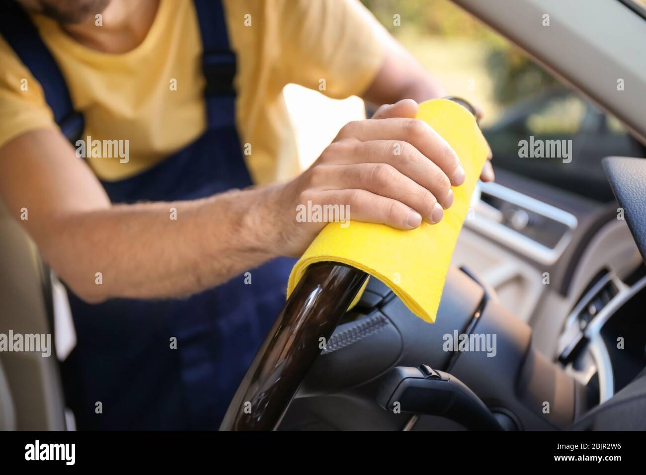 Man cleaning car steering wheel with rag, closeup Stock Photo - Alamy