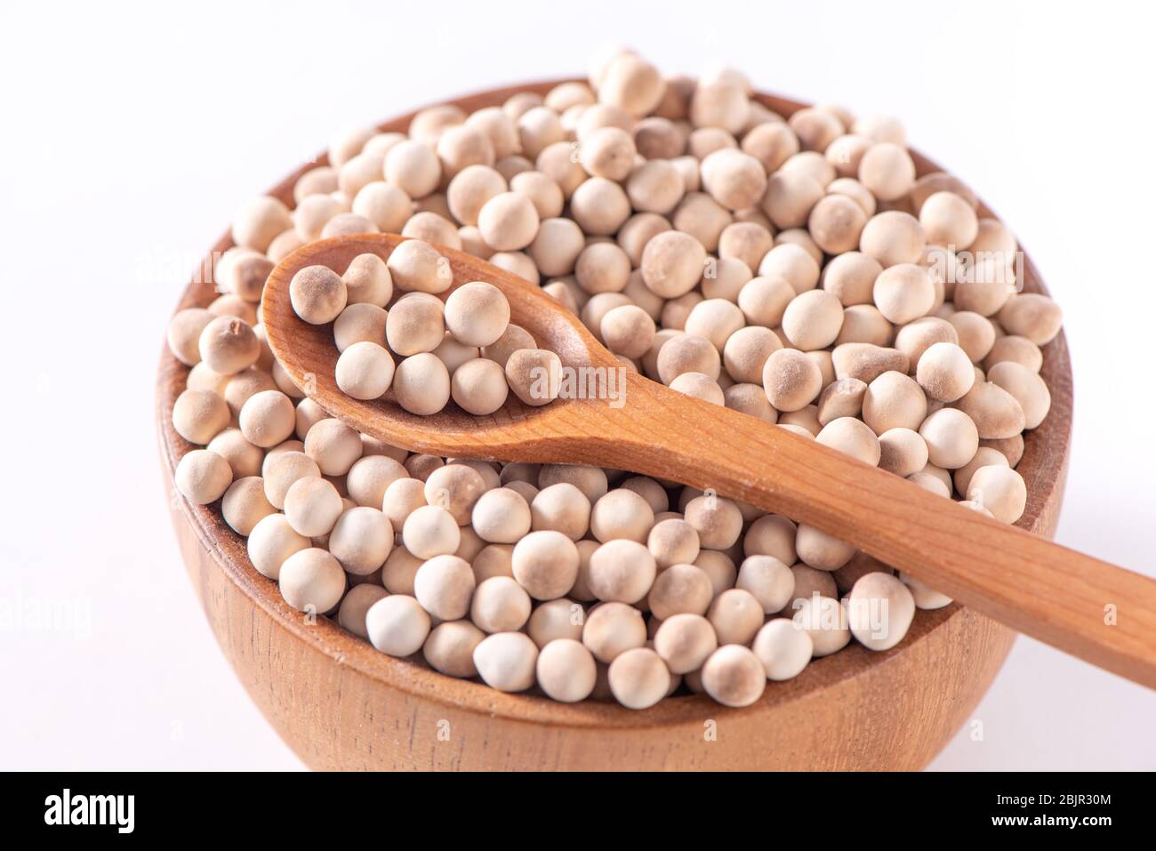 Dry raw brown tapioca pearls in a wooden bowl with spoon isolated on ...