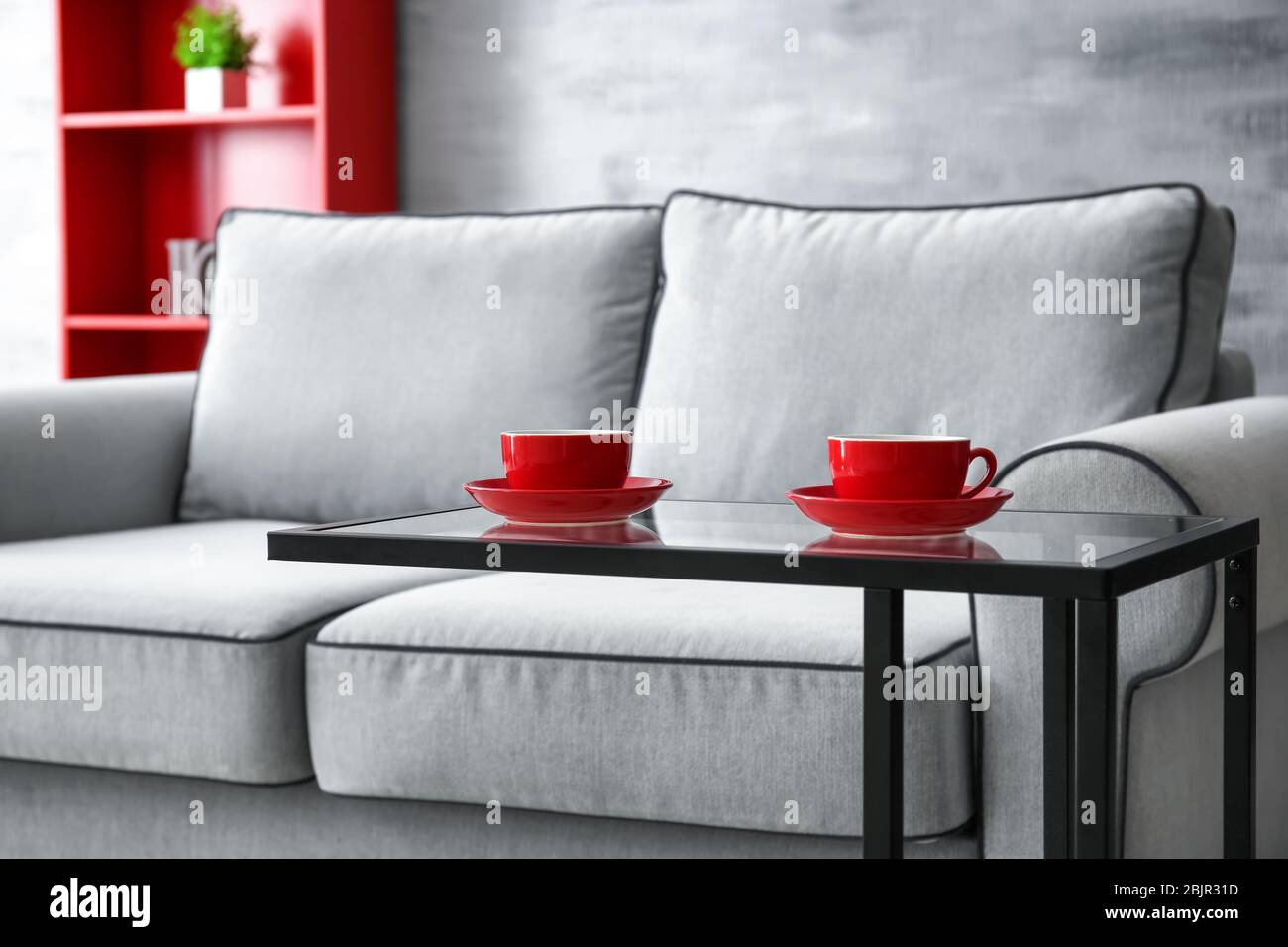 Stylish sofa with table in interior of living room Stock Photo - Alamy