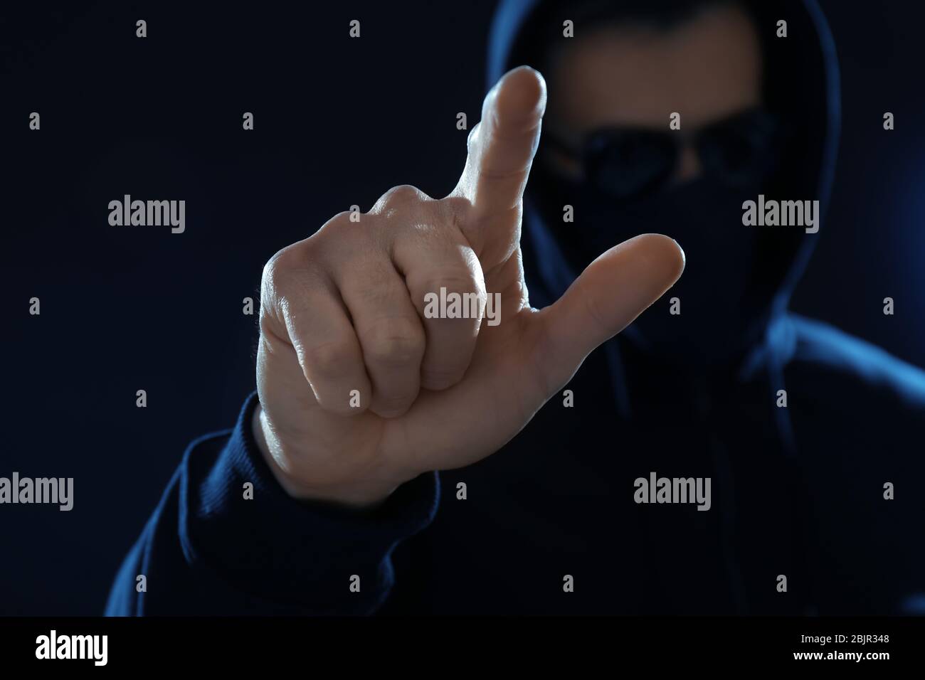 Hacker pushing button on virtual screen against dark background Stock ...