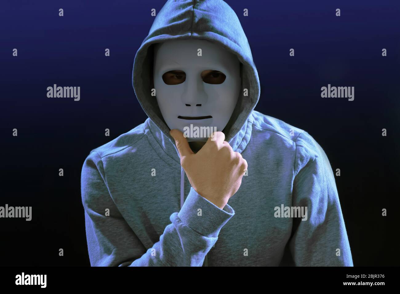 Hacker in mask on dark background Stock Photo - Alamy