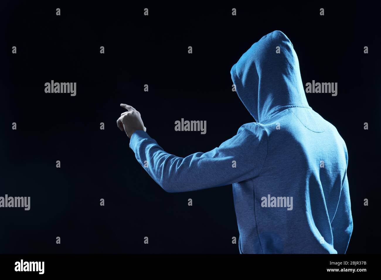 Hacker pushing button on virtual screen against dark background Stock ...