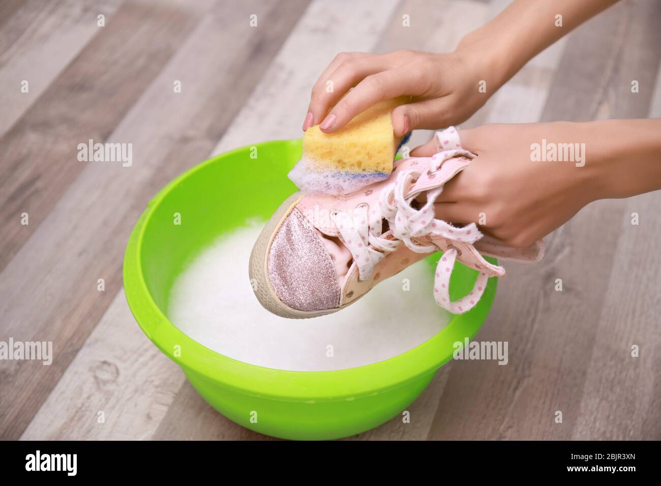 Woman washing sneaker with sponge over plastic basin, closeup Stock ...