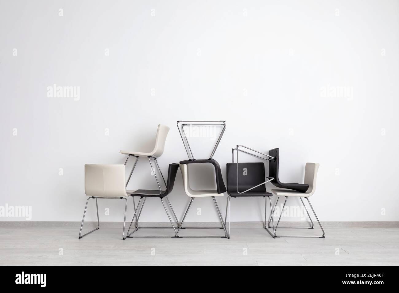 Composition with modern chairs near light wall Stock Photo - Alamy