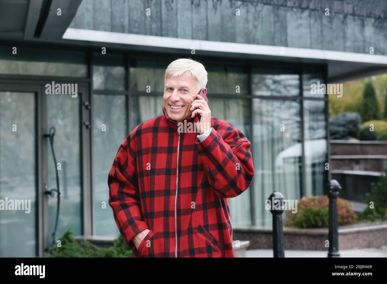 Handsome mature man talking on phone outdoors Stock Photo - Alamy