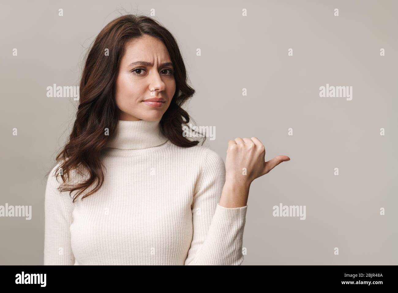 Photo of caucasian woman with long brown hair frowning and gesturing at ...
