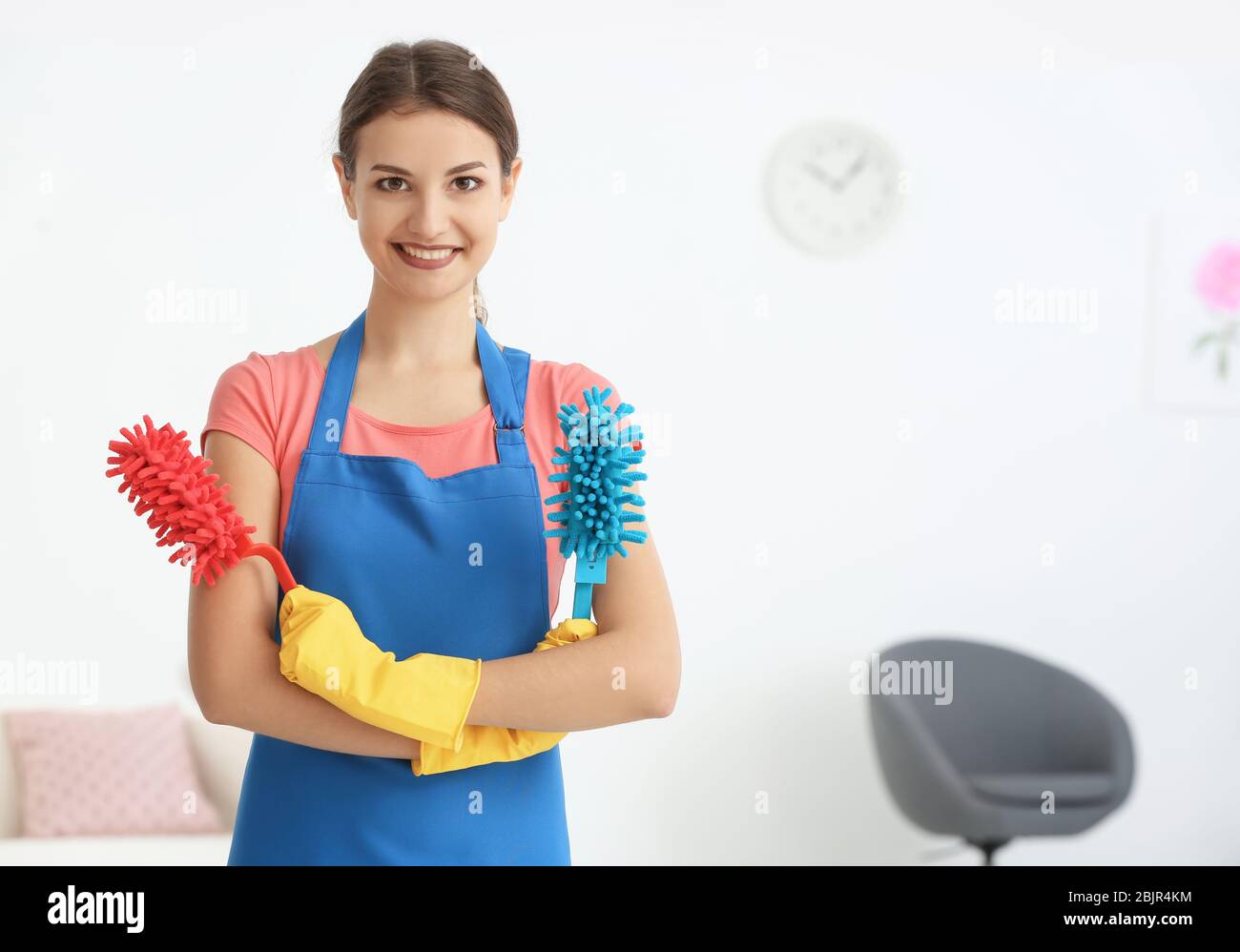 Young woman with dusters in flat Stock Photo - Alamy
