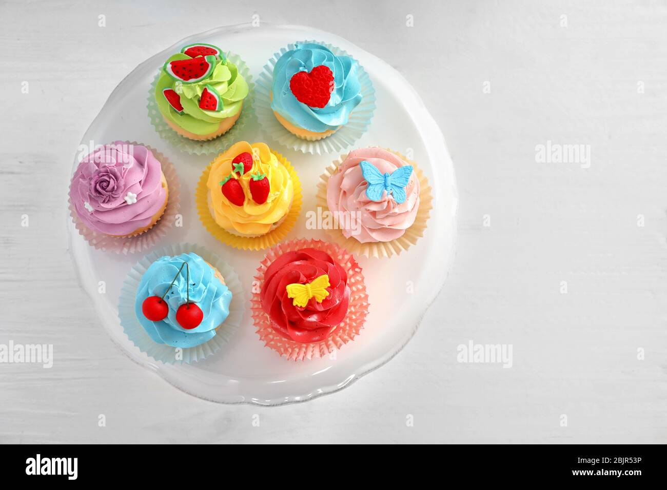 Stand with beautiful cupcakes on white table Stock Photo - Alamy