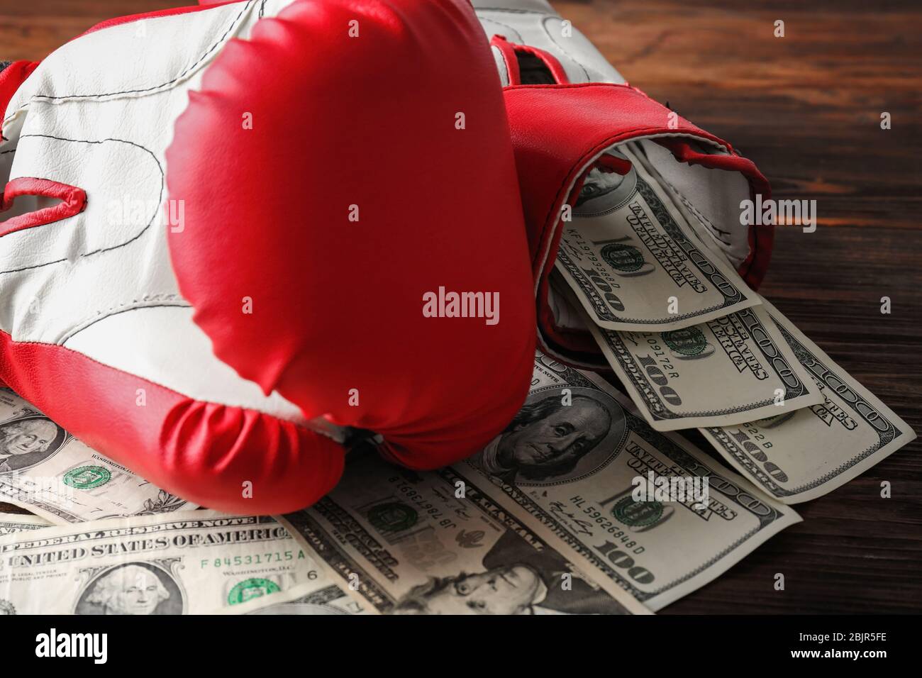 Boxing gloves and money on wooden background Stock Photo - Alamy