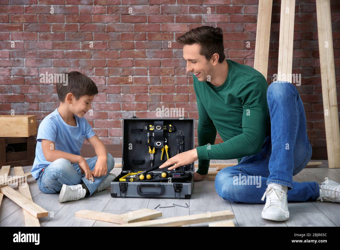 Father showing his little son different tools in workshop Stock Photo ...