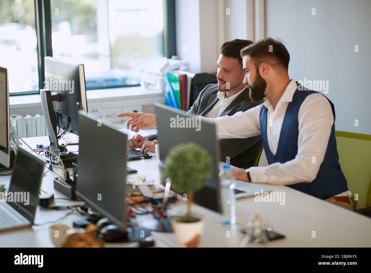 Landing a helping hand at work from colleagues, young businesspeople ...
