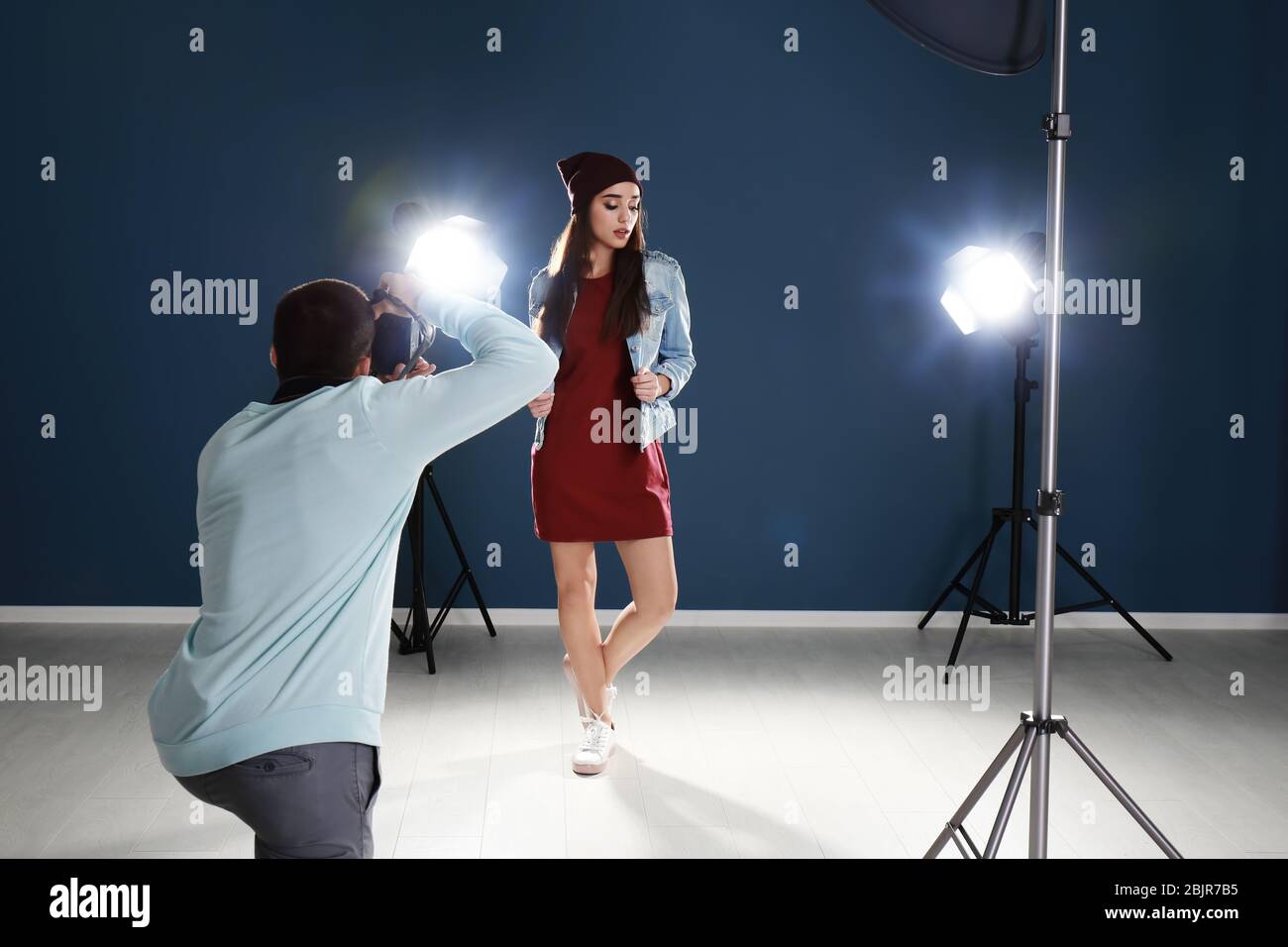 Beautiful young model posing for professional photographer in studio ...