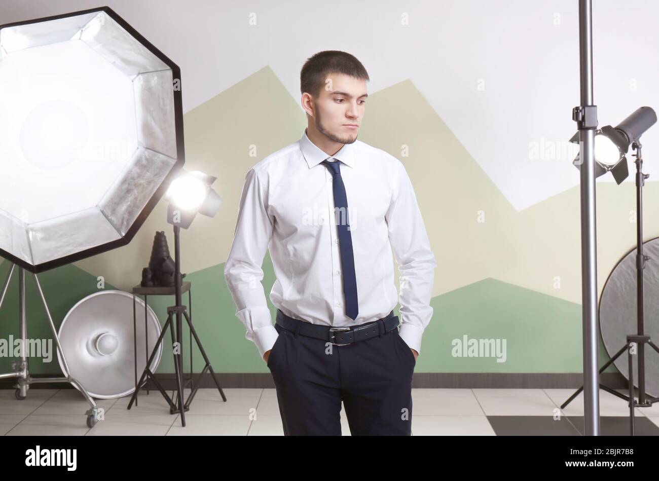 Young man posing in professional photo studio Stock Photo - Alamy