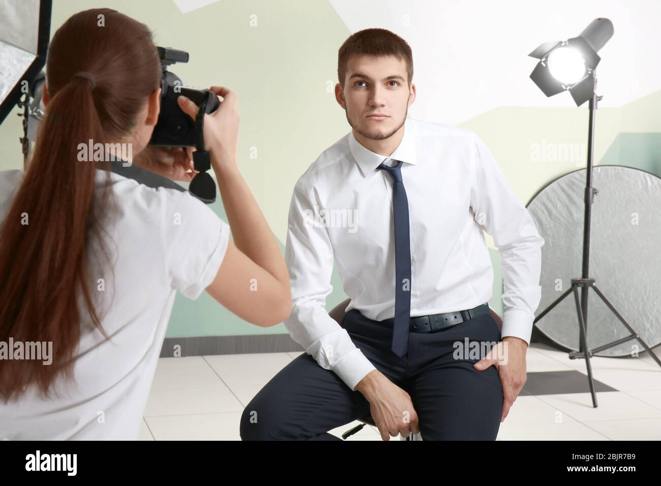 Young man posing for professional photographer in studio Stock Photo ...