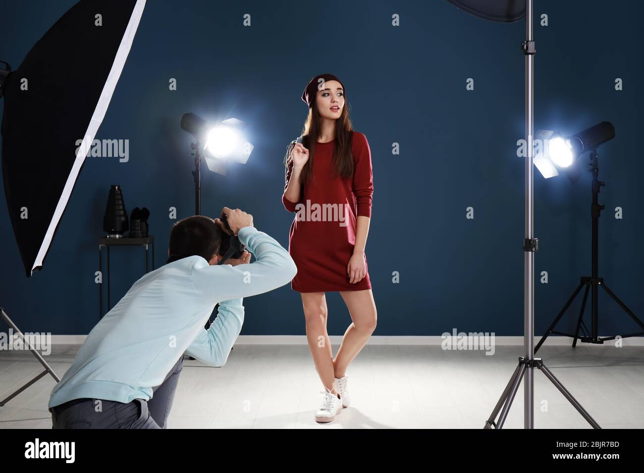 Beautiful young model posing for professional photographer in studio ...