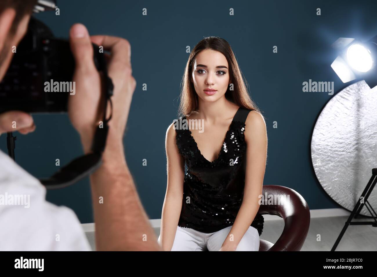 Beautiful young model posing for professional photographer in studio ...