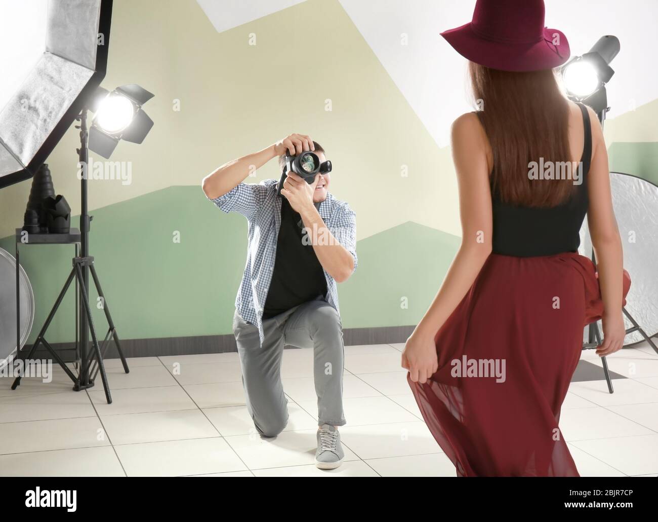 Beautiful young model posing for professional photographer in studio ...