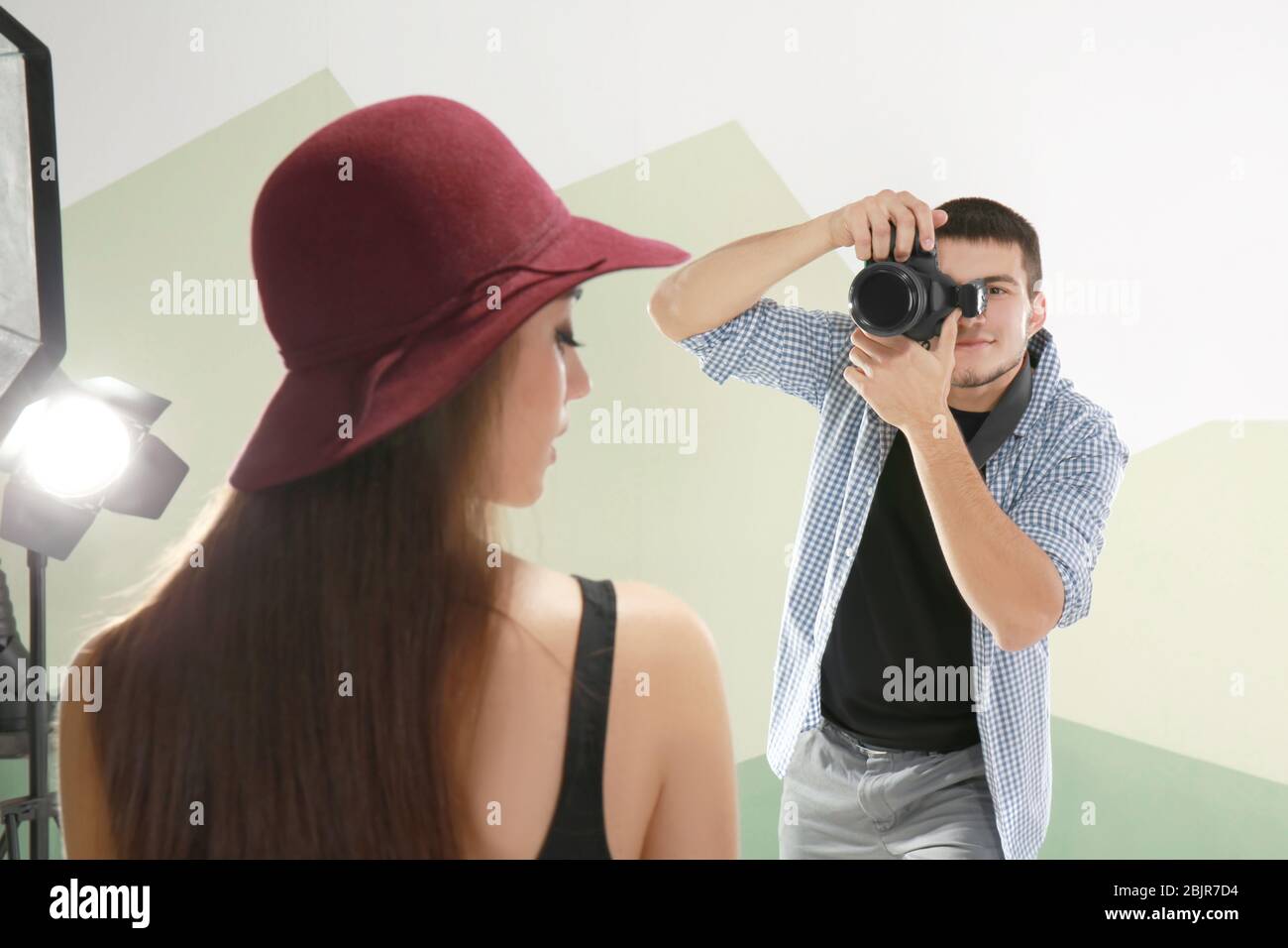 Beautiful young model posing for professional photographer in studio ...
