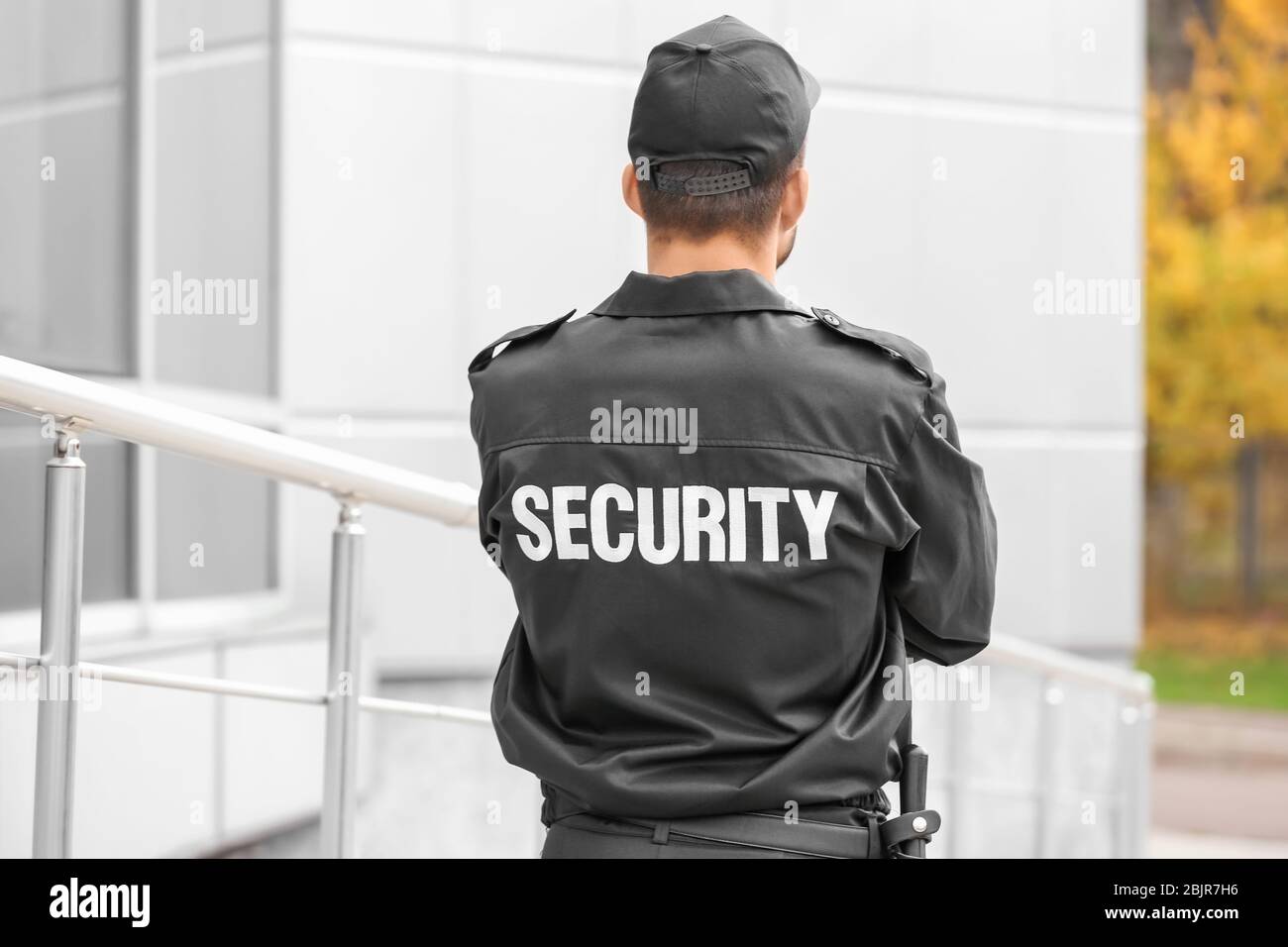 Male security guard near building outdoors Stock Photo - Alamy
