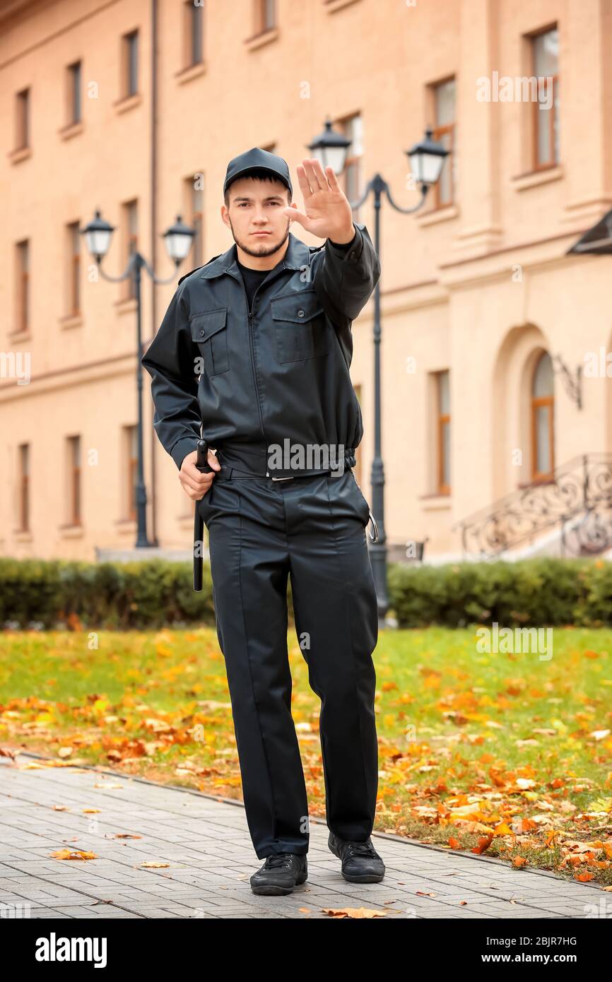 Male security guard with police baton on city street Stock Photo - Alamy