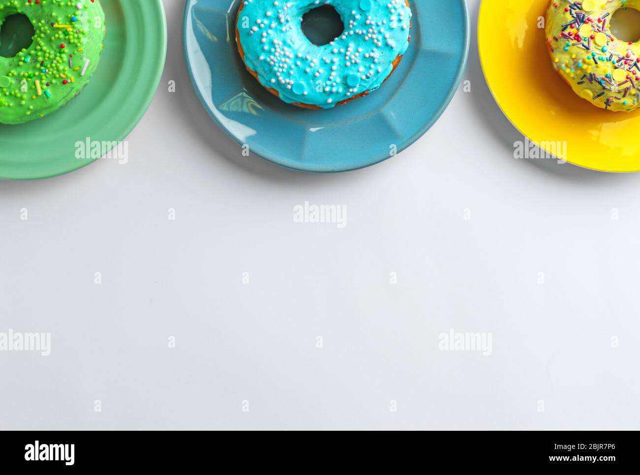 Plates with different donuts on white background Stock Photo - Alamy