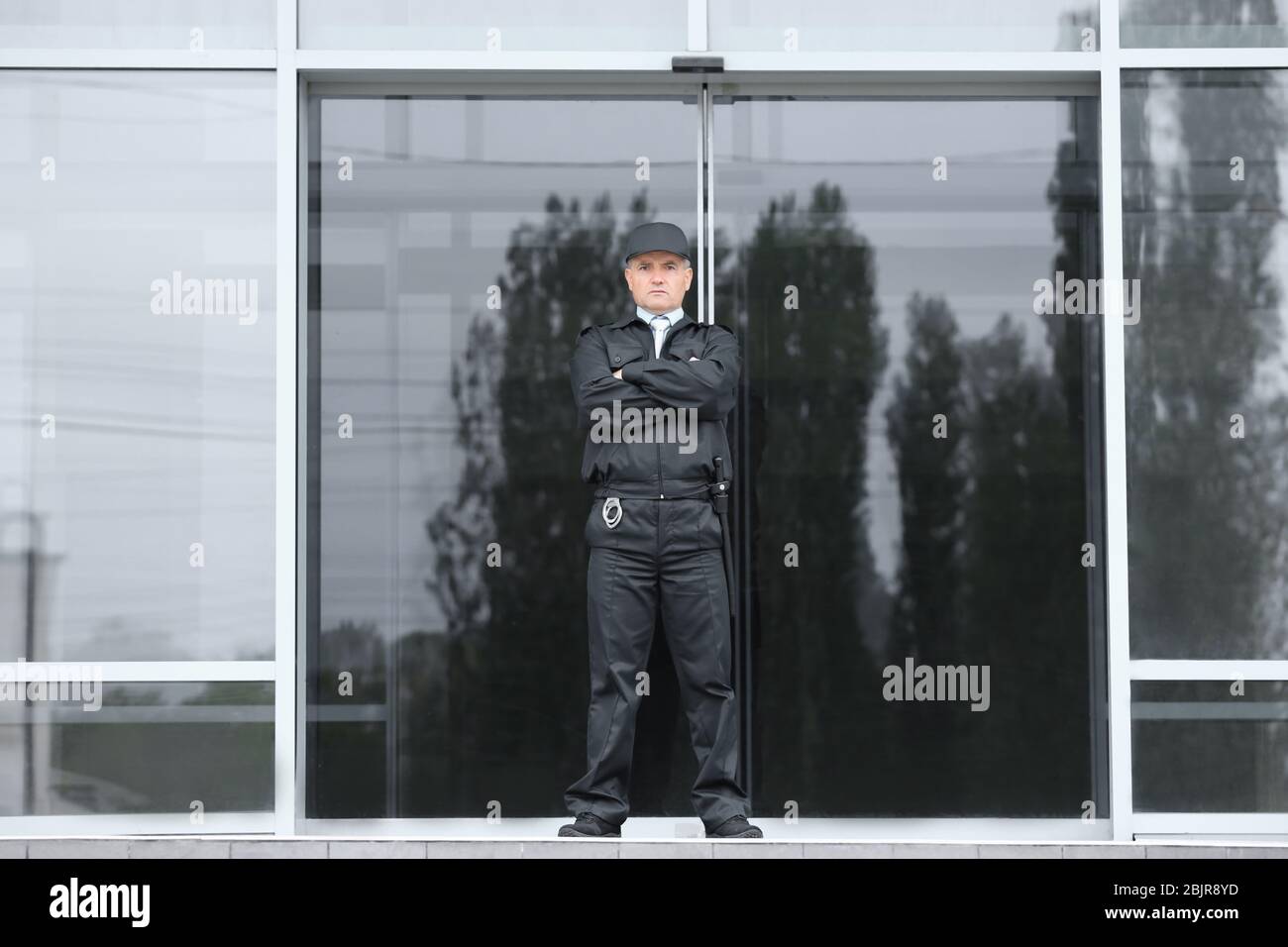 Male security guard standing outdoors Stock Photo - Alamy