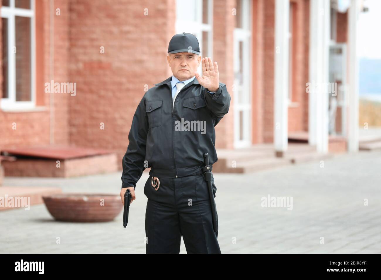 Male security guard standing outdoors Stock Photo - Alamy