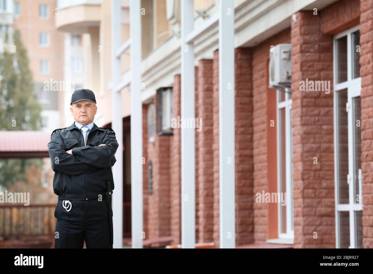 Male security guard standing outdoors Stock Photo - Alamy