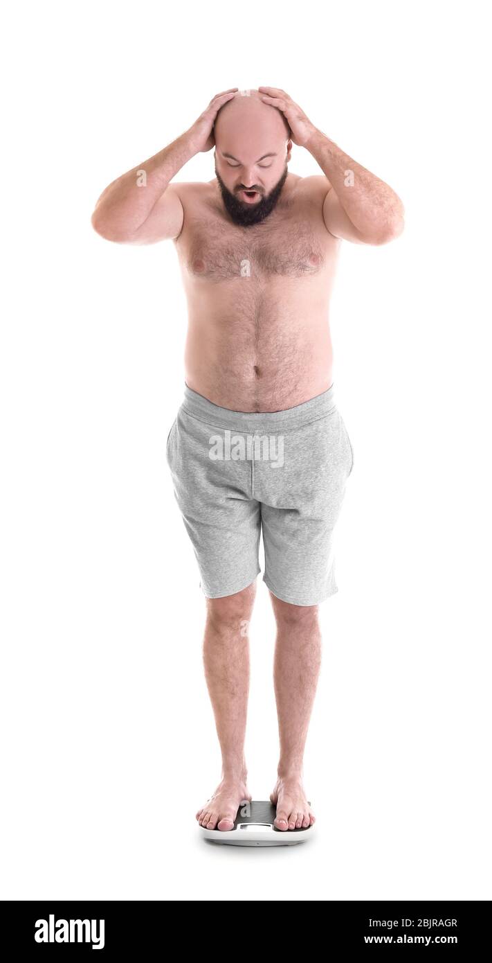 Overweight man measuring his weight using scales on white background ...