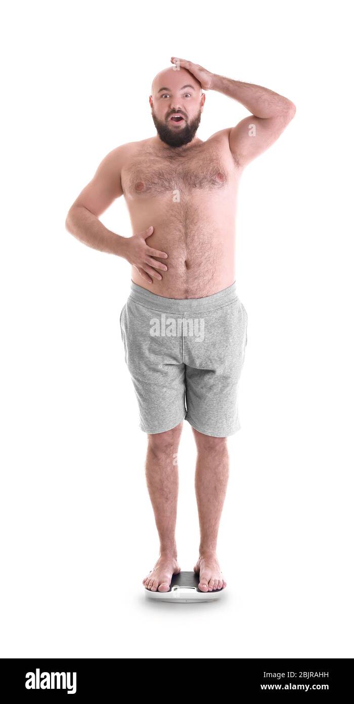Overweight man measuring his weight using scales on white background ...