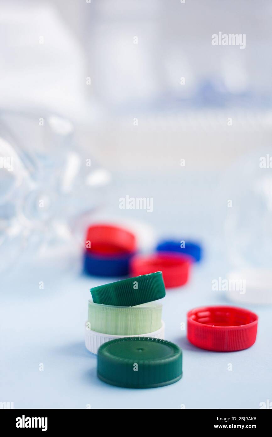 Colorful plastic caps against bottles. Plastic wrapping rubbish on blue ...