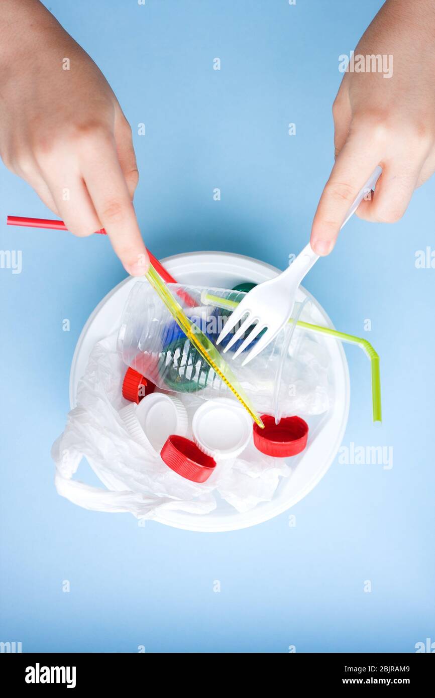 Pile of single use plastic garbage including straws, glass, plate and ...