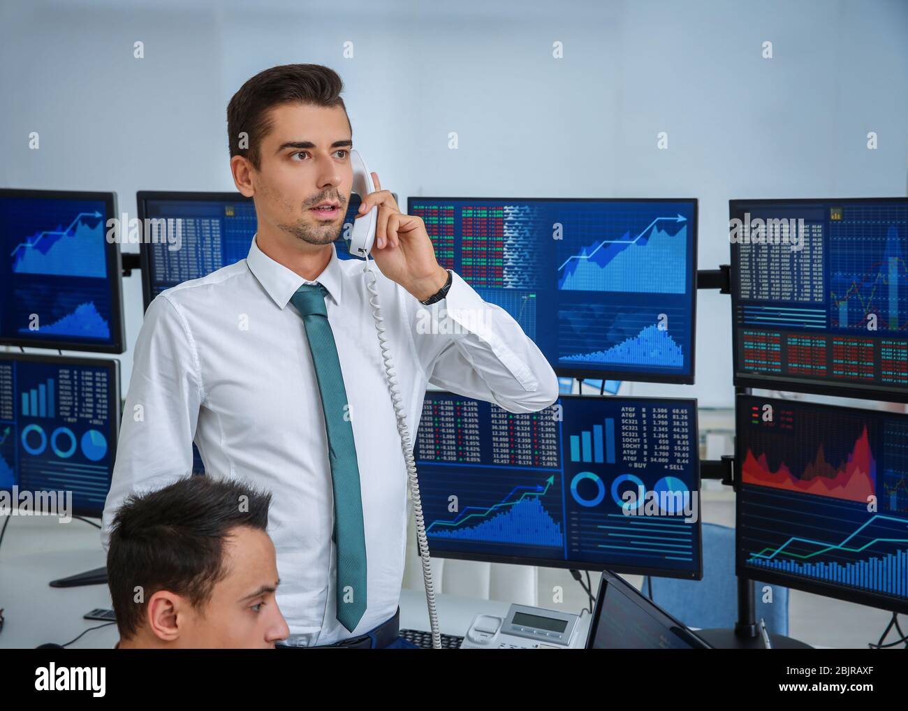 Male stock trader working in office Stock Photo - Alamy
