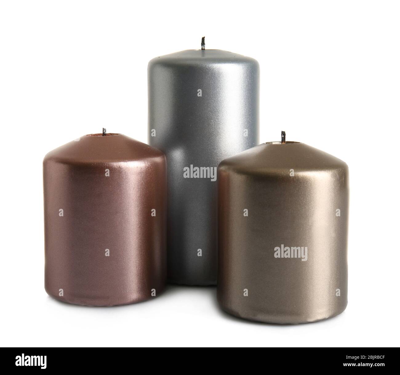 Metallic pillar candles on table against white background Stock Photo ...