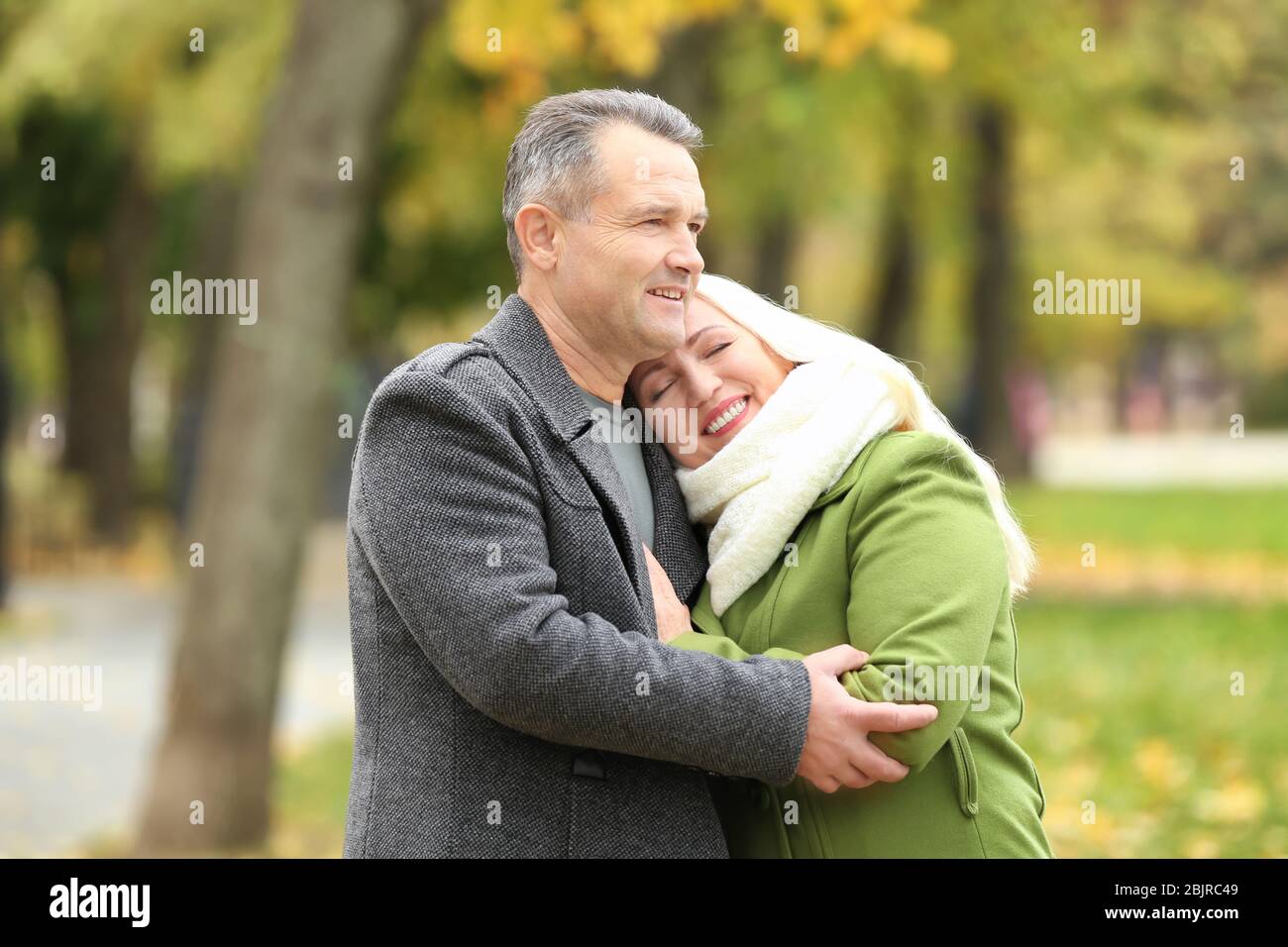 Happy mature couple hugging in park Stock Photo - Alamy