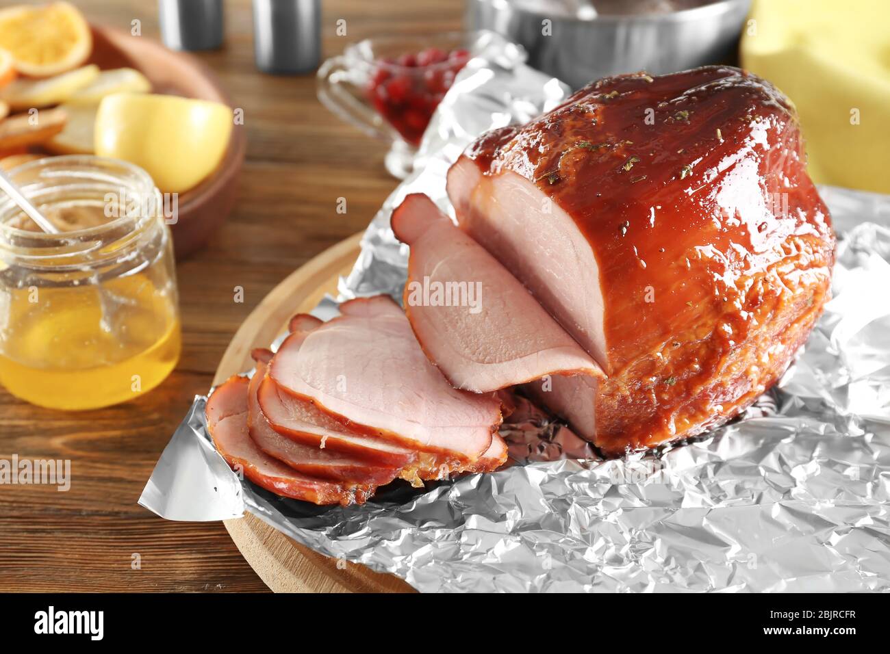 Board with traditional sliced honey baked ham on table Stock Photo - Alamy