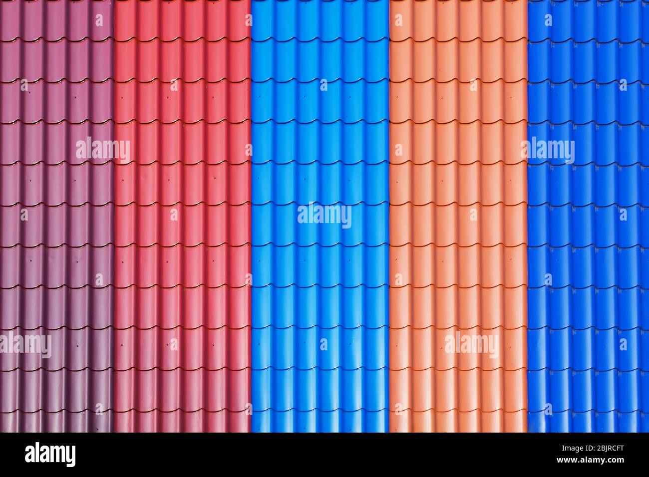 multicolored, metallic sheets of undulating decorative siding Stock ...