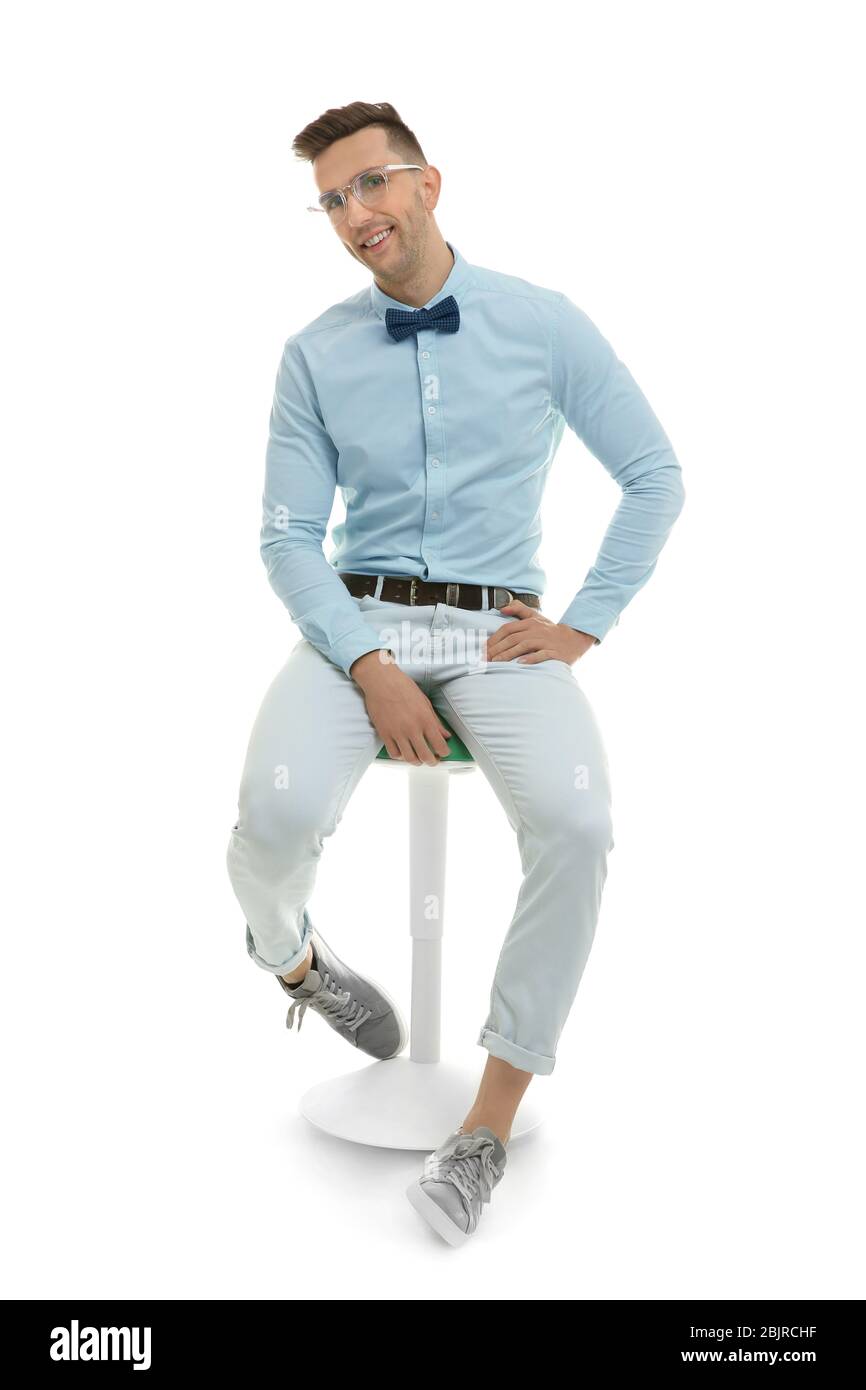 Handsome young man sitting on stool, isolated on white Stock Photo - Alamy