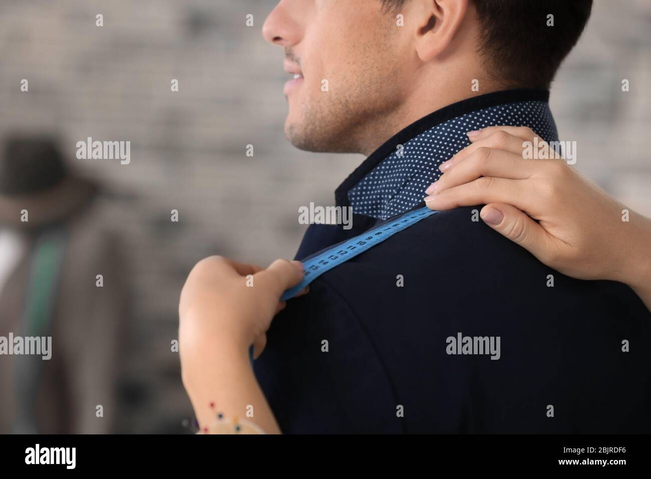 Seamstress taking client's measurements in atelier Stock Photo - Alamy