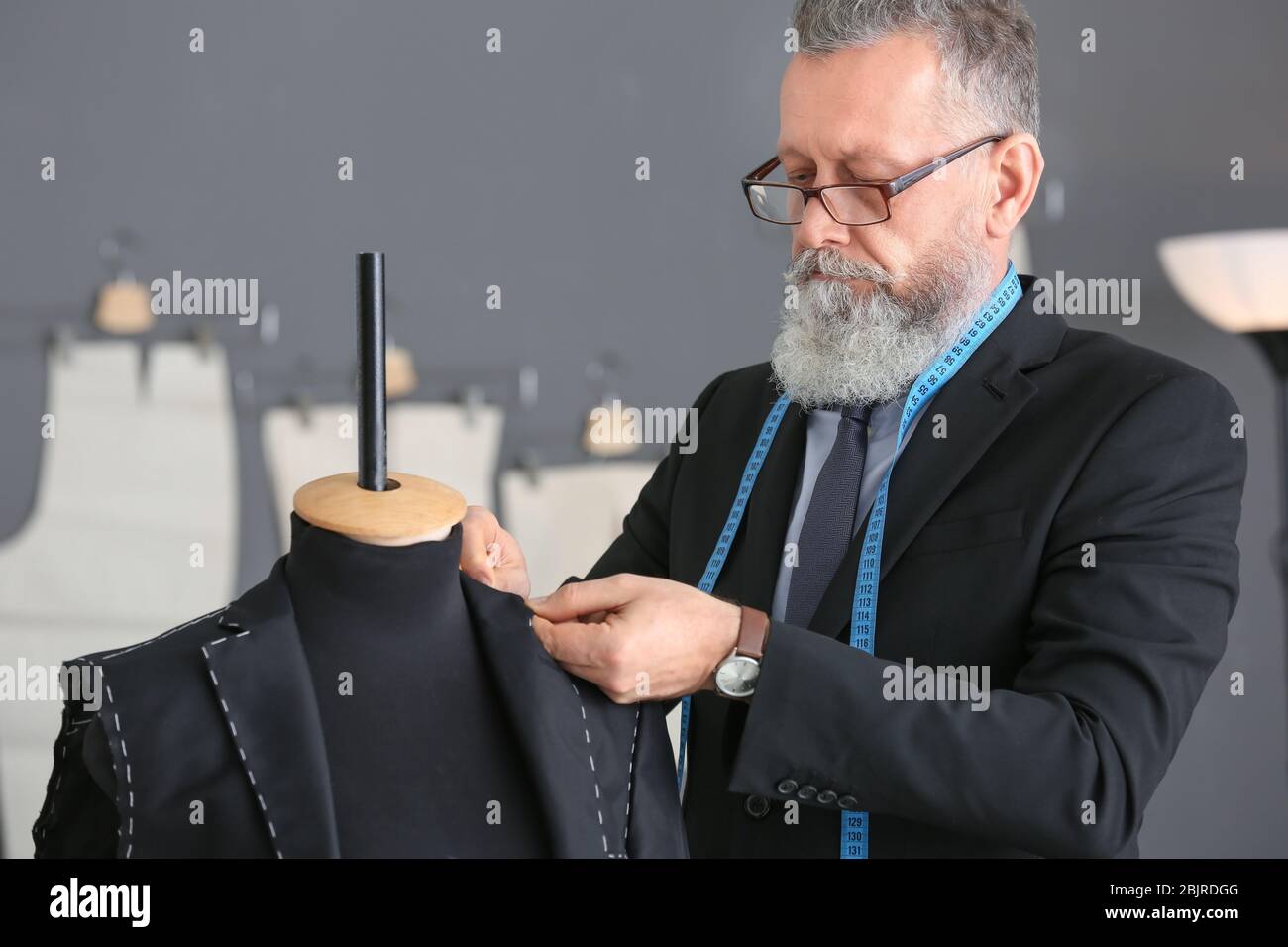 Senior man tailoring formal suit in atelier Stock Photo - Alamy