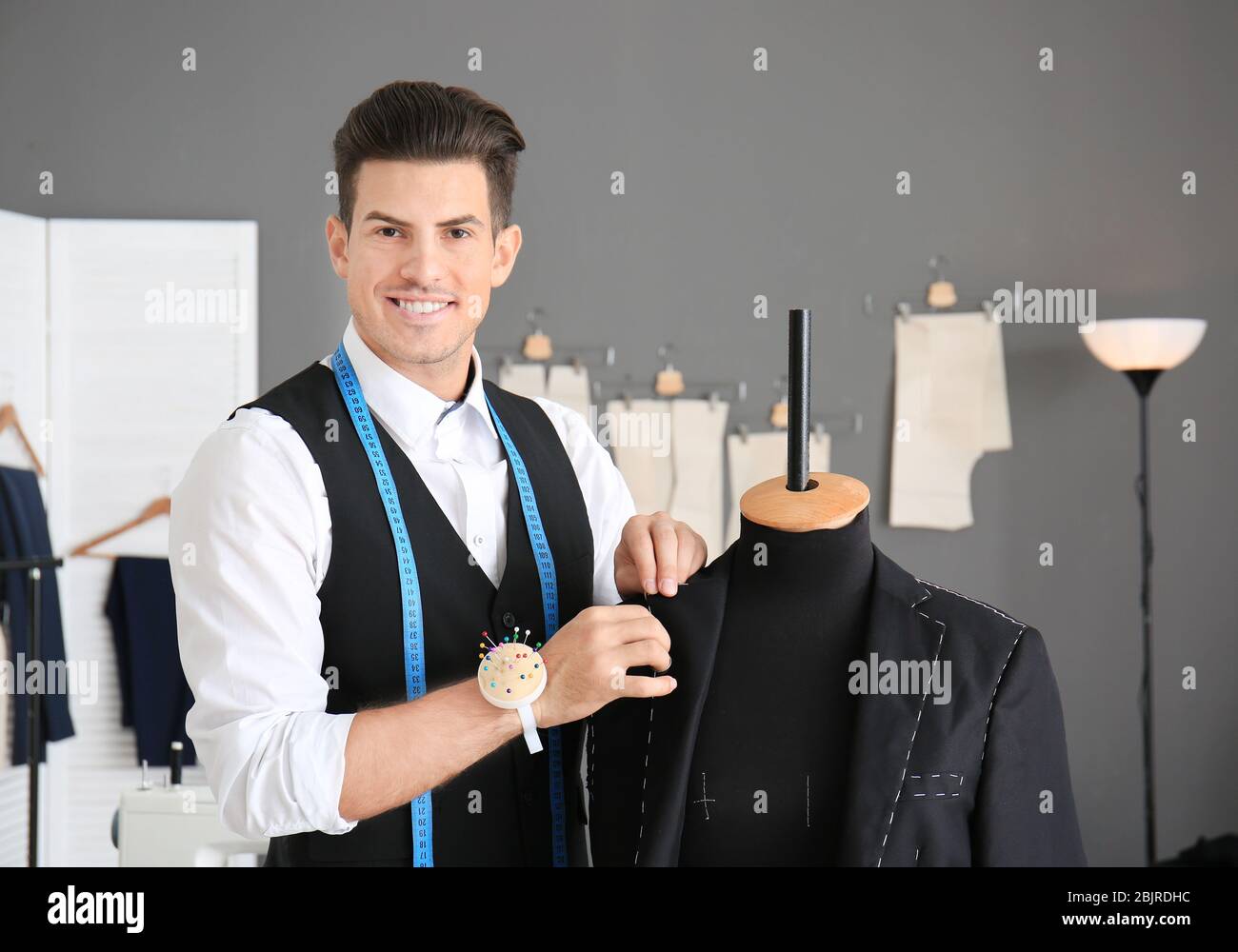 Young man tailoring formal suit in atelier Stock Photo - Alamy