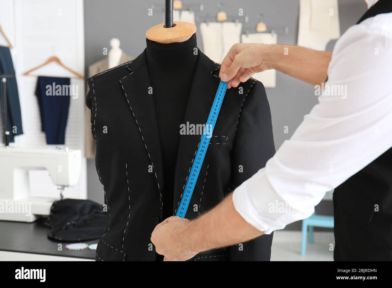 Tailor taking measurements of mannequin in atelier Stock Photo - Alamy