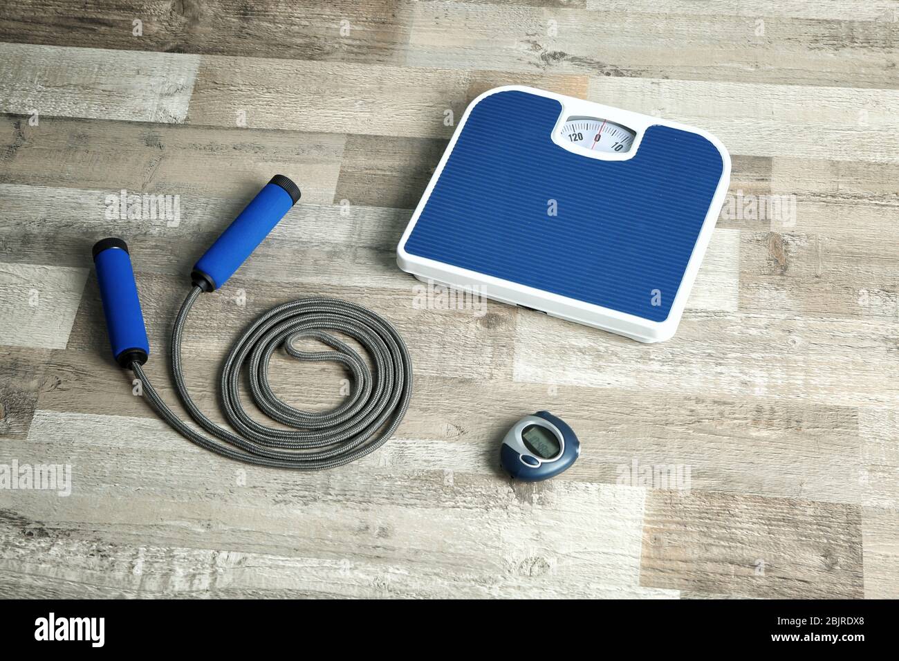 Jumping rope, timer and bathroom scales on wooden background Stock ...