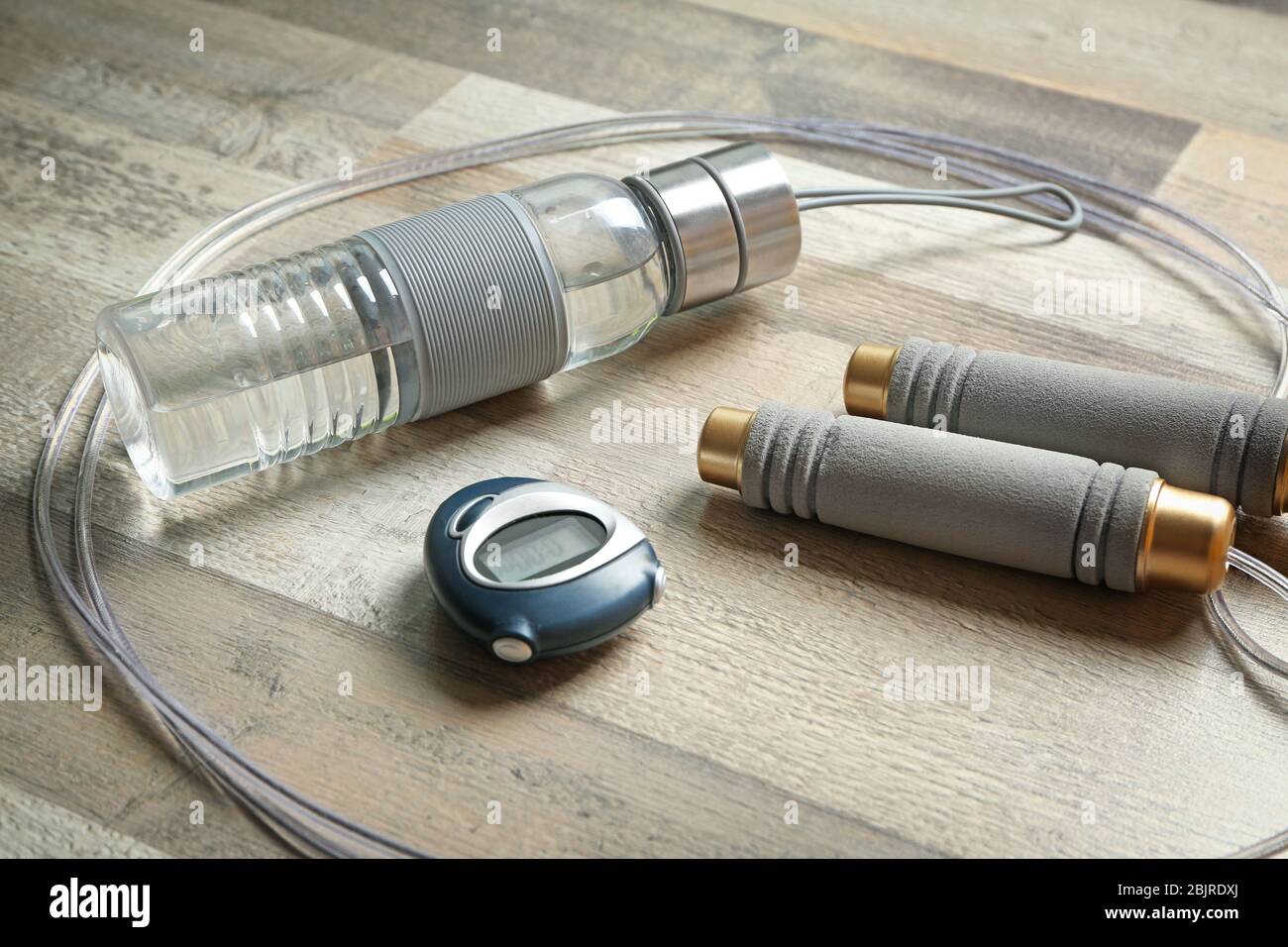Jumping rope, timer and bottle on wooden background Stock Photo - Alamy