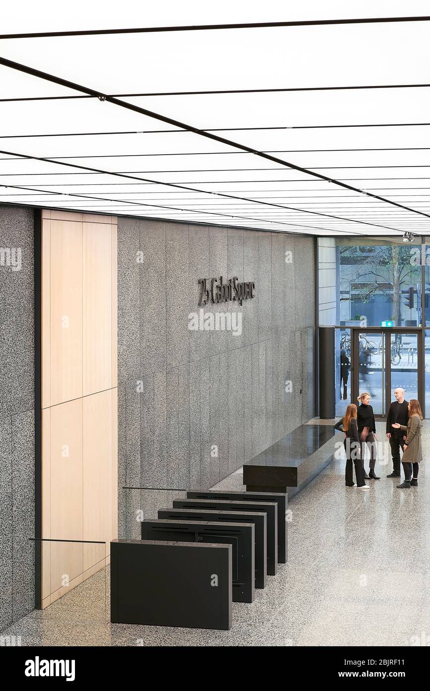 Corporate reception space with illuminated ceiling and security gates ...