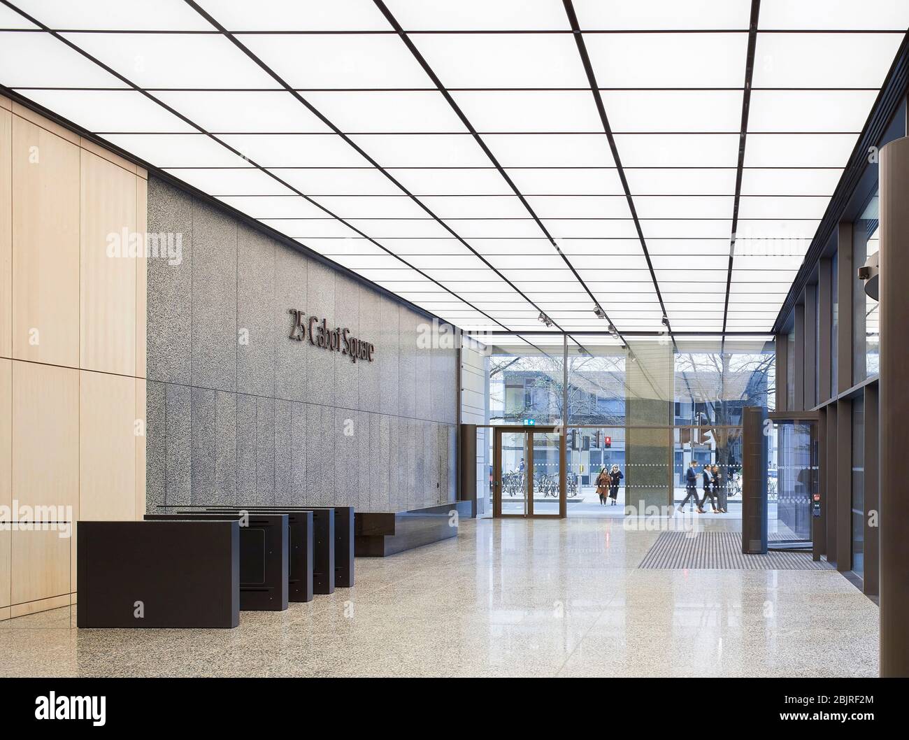 Corporate reception space with illuminated ceiling and security gates ...