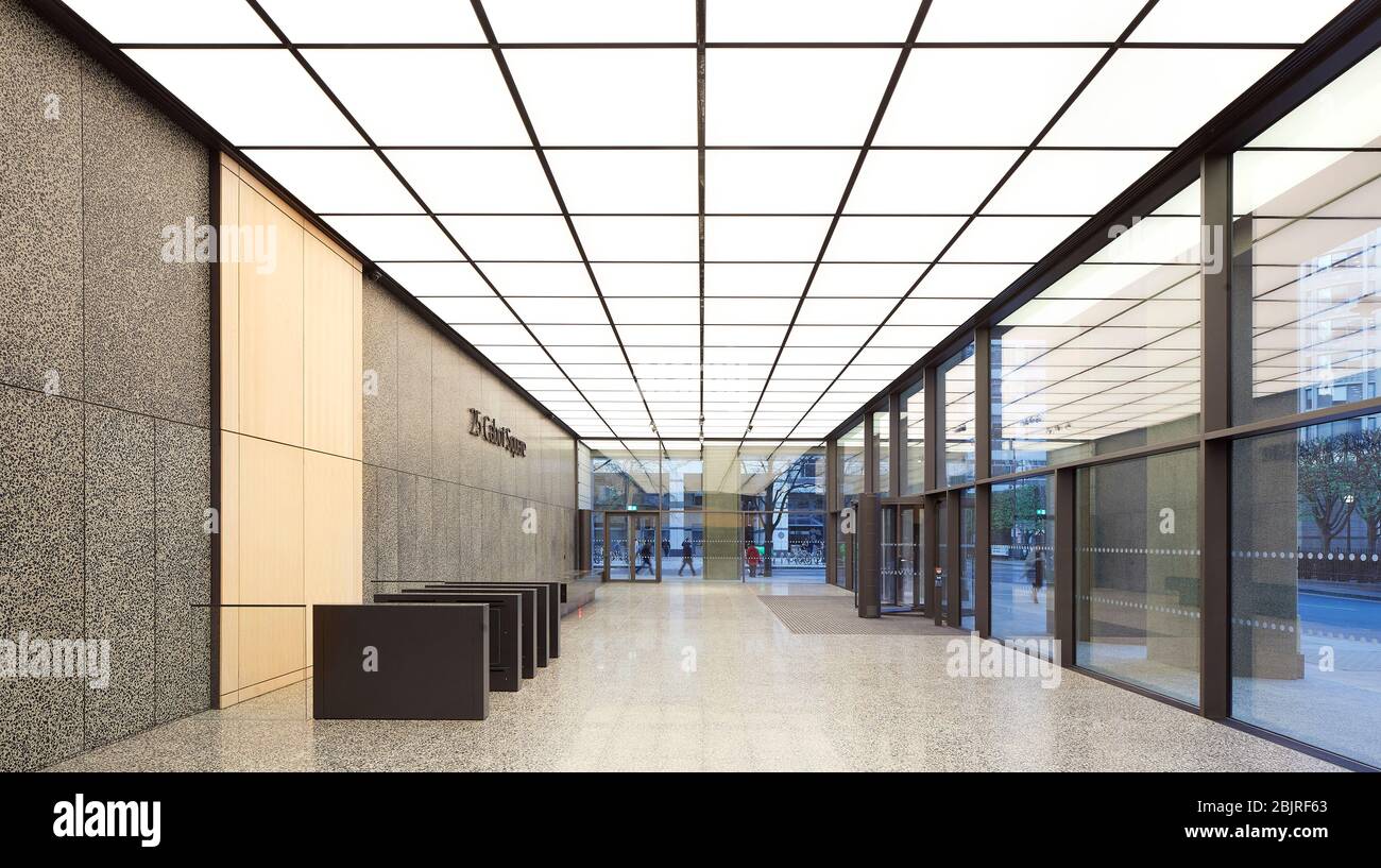 Corporate reception space with illuminated ceiling and security gates ...