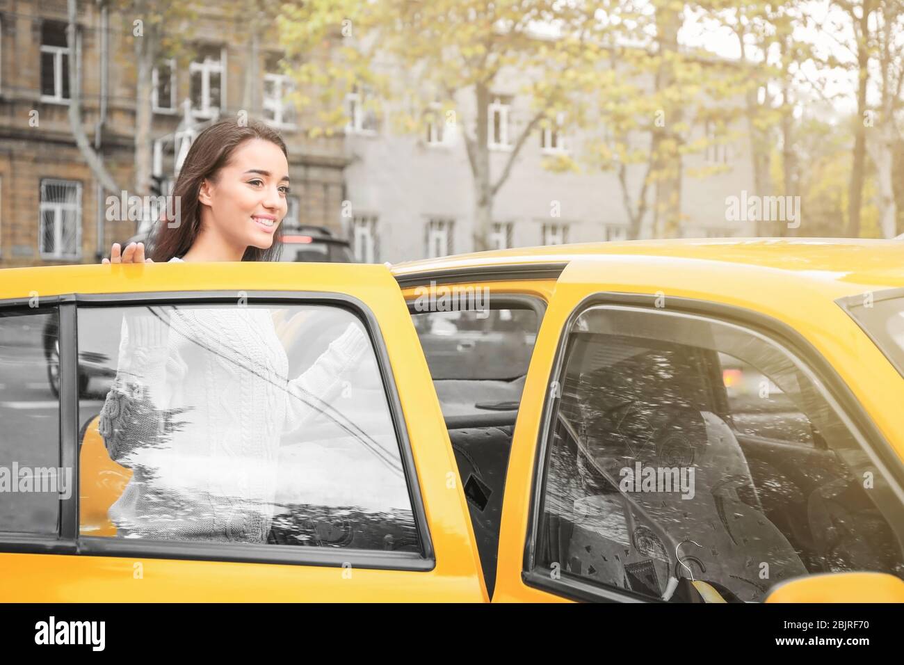 Young woman getting into cab hi-res stock photography and images - Alamy